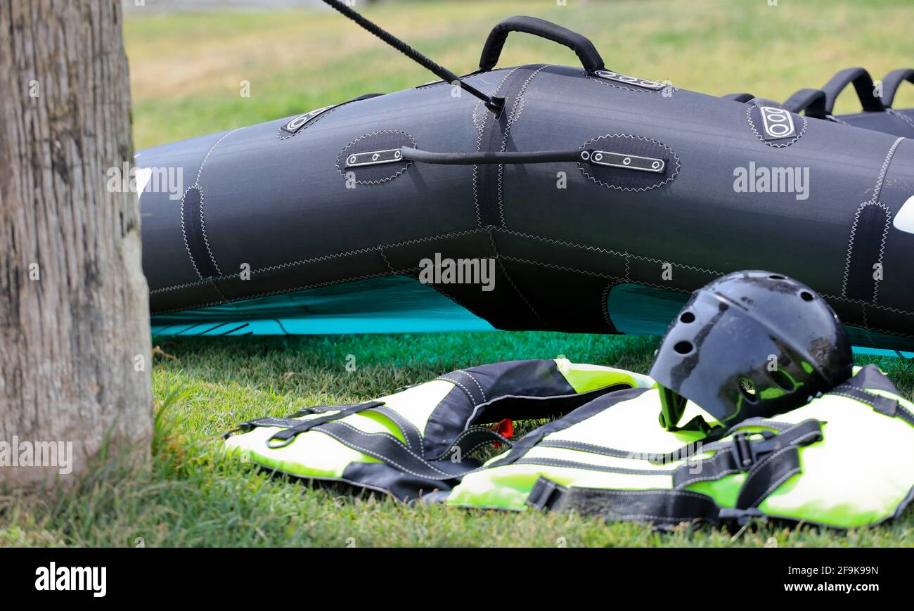 windfoil equipment on the green grass, with kite, helmet, and harness ...