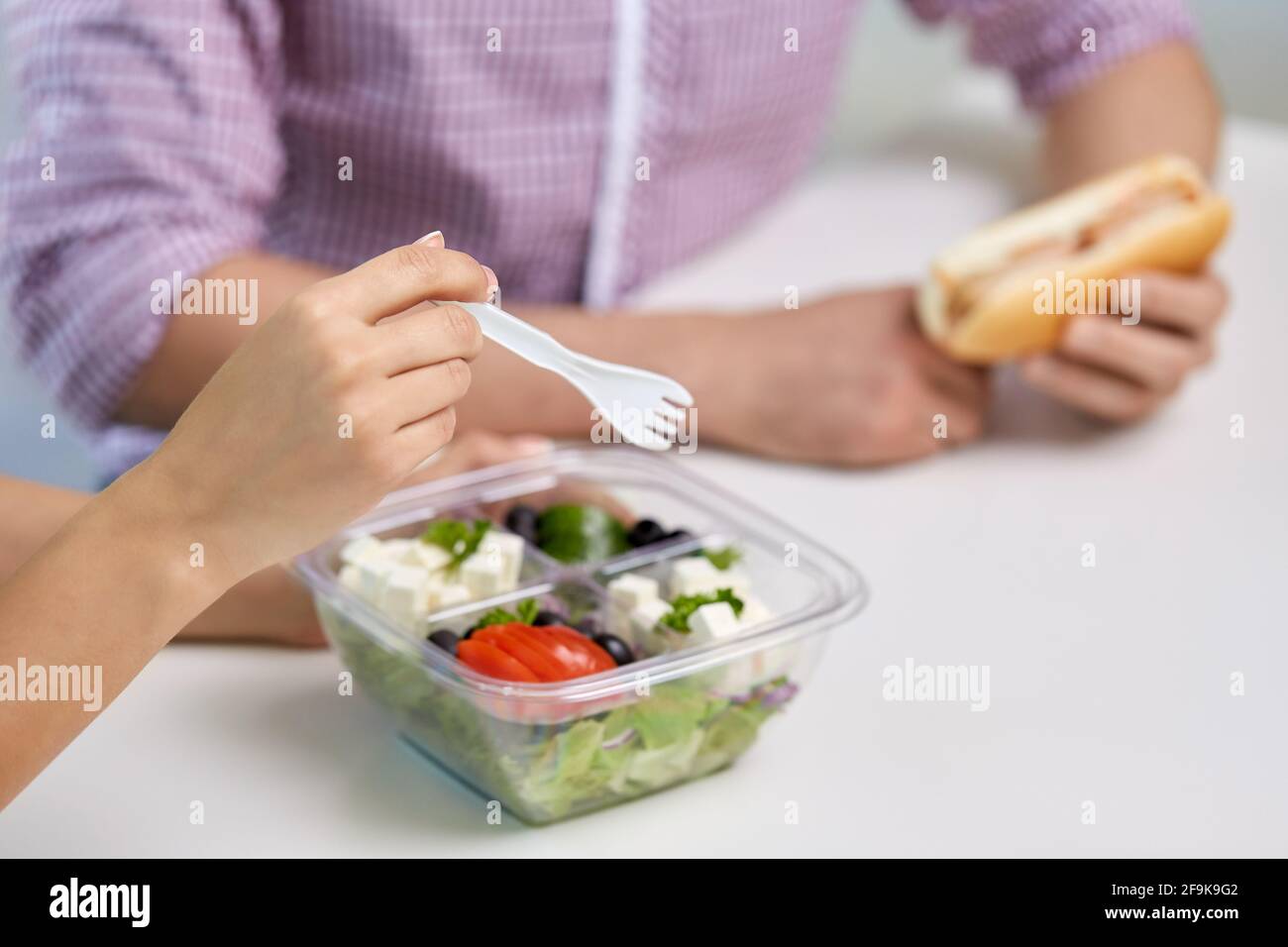 hands of woman eating take out food from container Stock Photo - Alamy