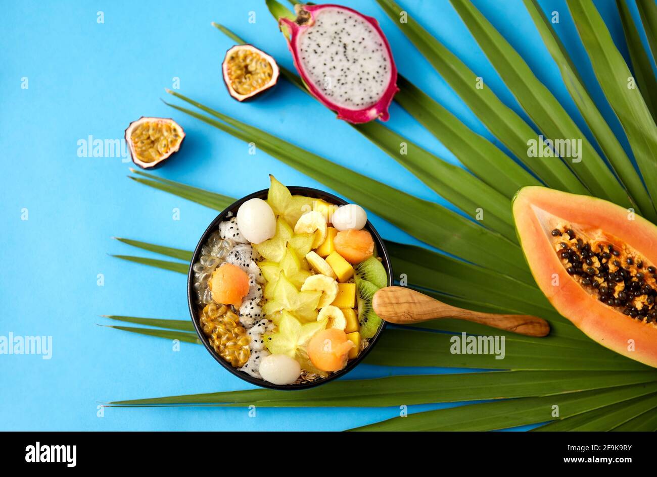 mix of exotic fruits in bowl with wooden spoon Stock Photo - Alamy
