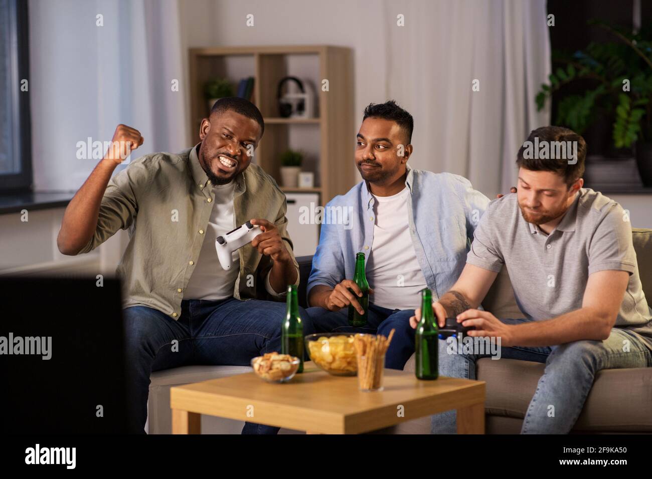 happy friends playing video games at home at night Stock Photo - Alamy