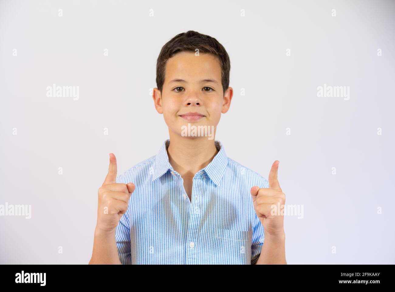 Cheerful smiling boy pointing up over white background Stock Photo - Alamy