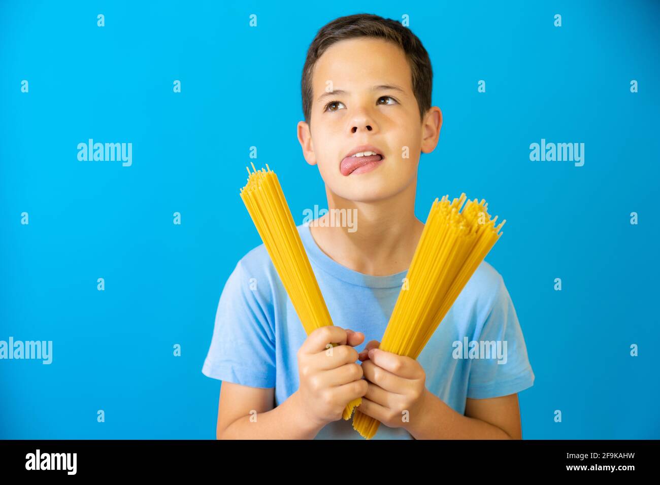 Cute smiling boy holding traditional Italian spaghetti in his hands ...