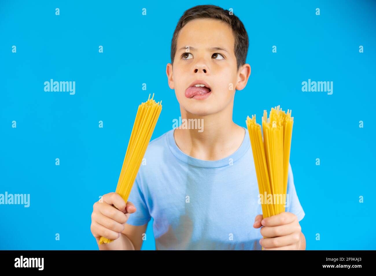 Cute smiling boy holding traditional Italian spaghetti in his hands ...