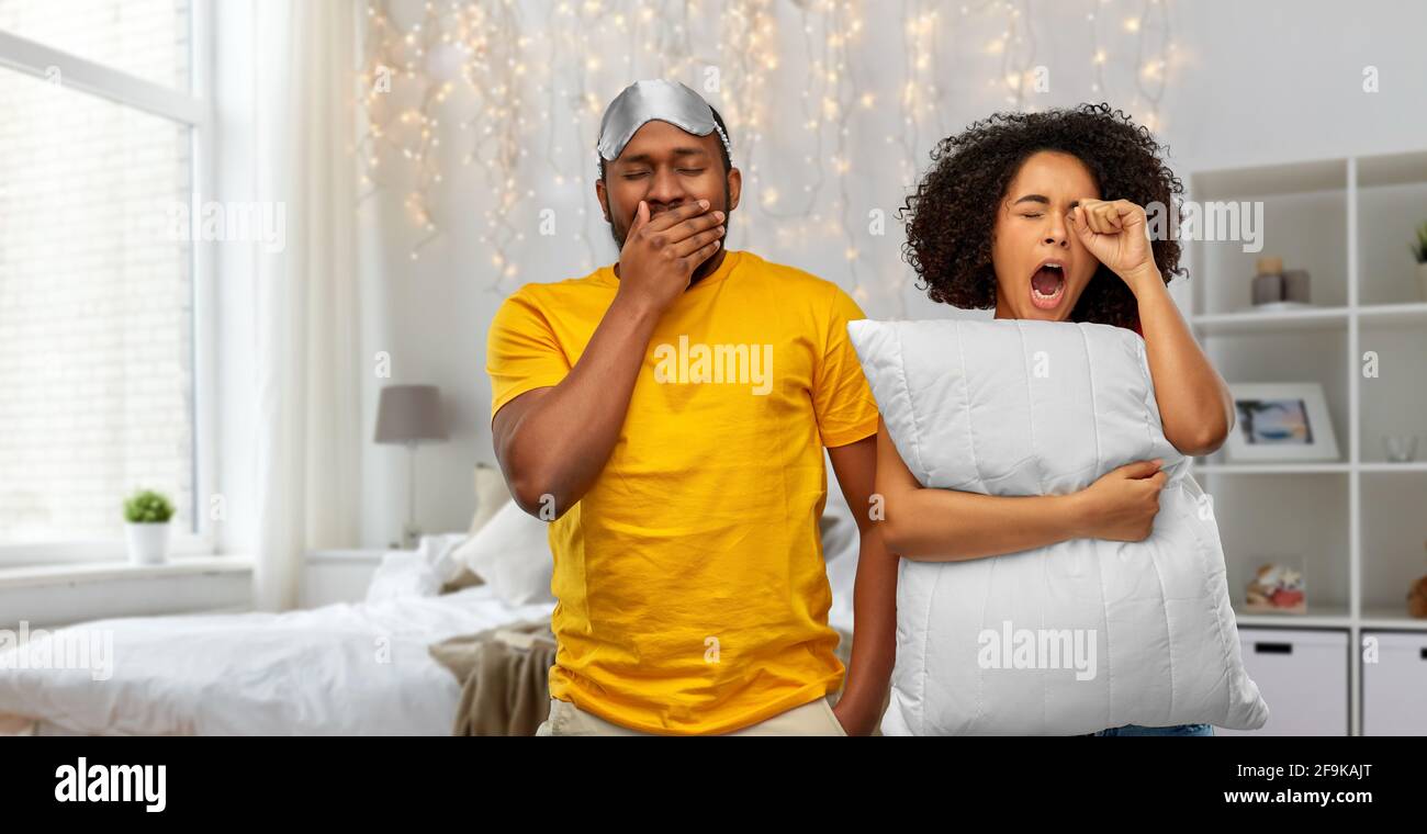 sleepy african american couple over bedroom Stock Photo - Alamy