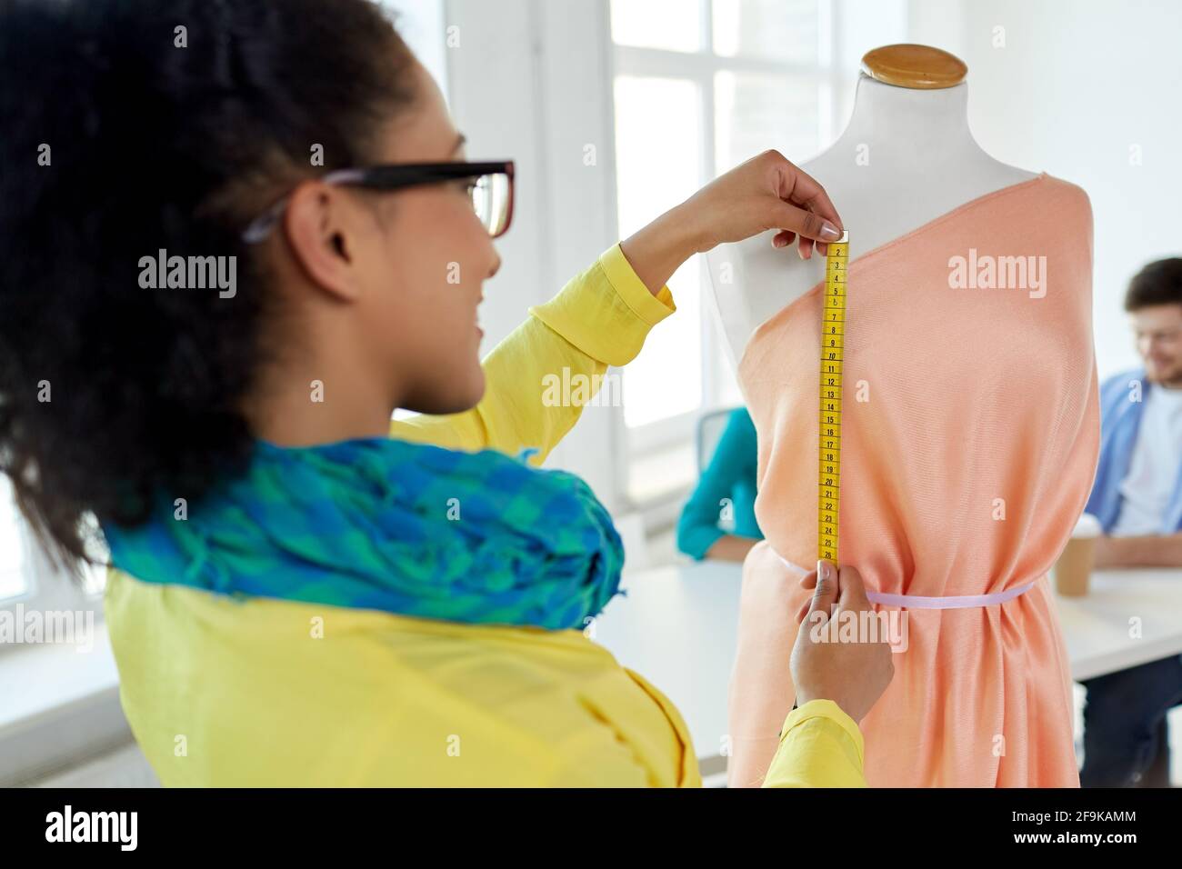 fashion designer measuring dress with tape measure Stock Photo - Alamy