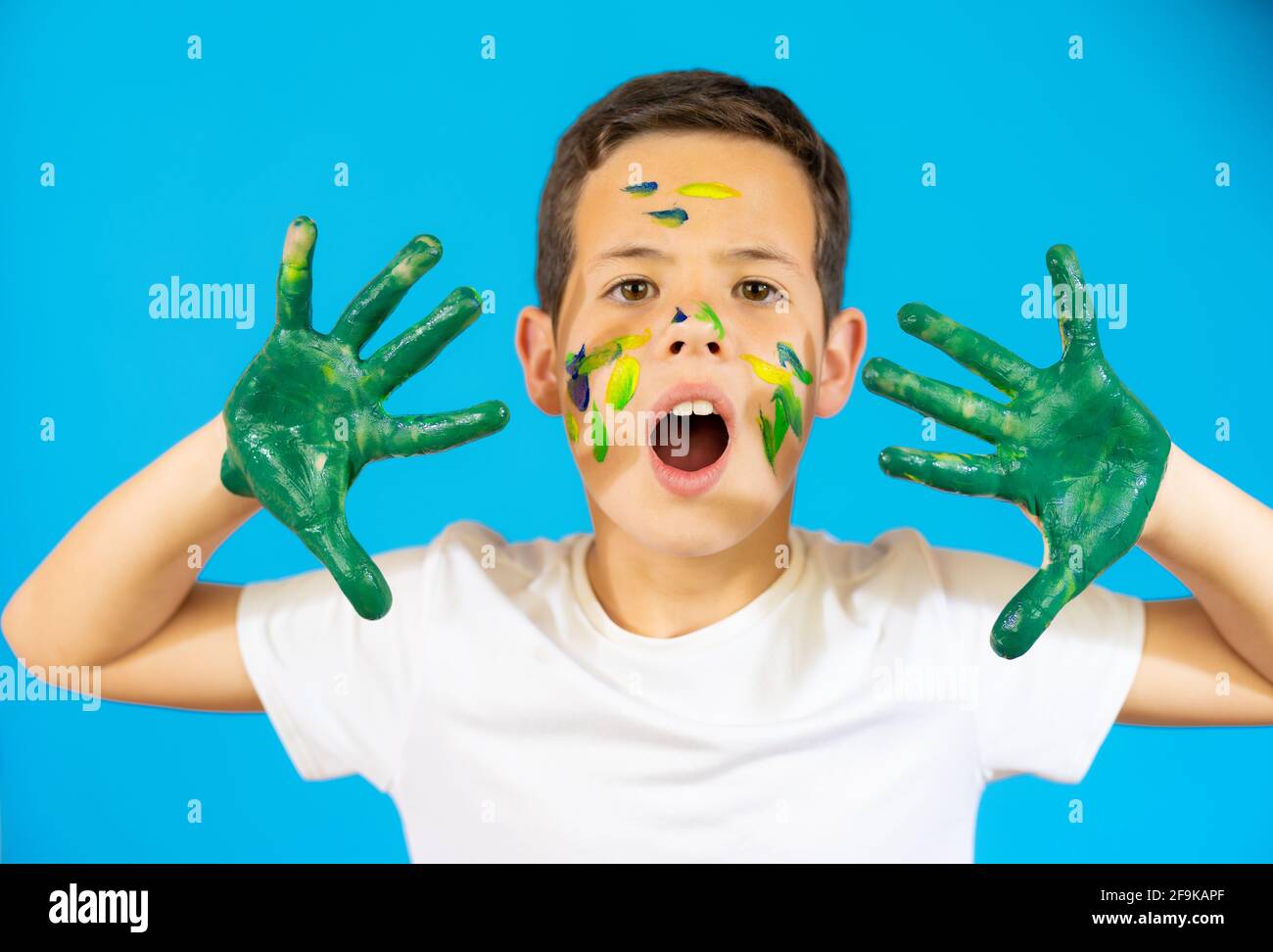 Cute boy with finger paint isolated over blue background Stock Photo ...