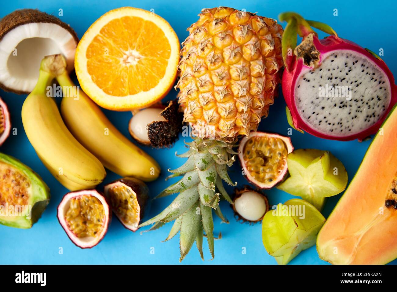 different exotic fruits on blue background Stock Photo - Alamy