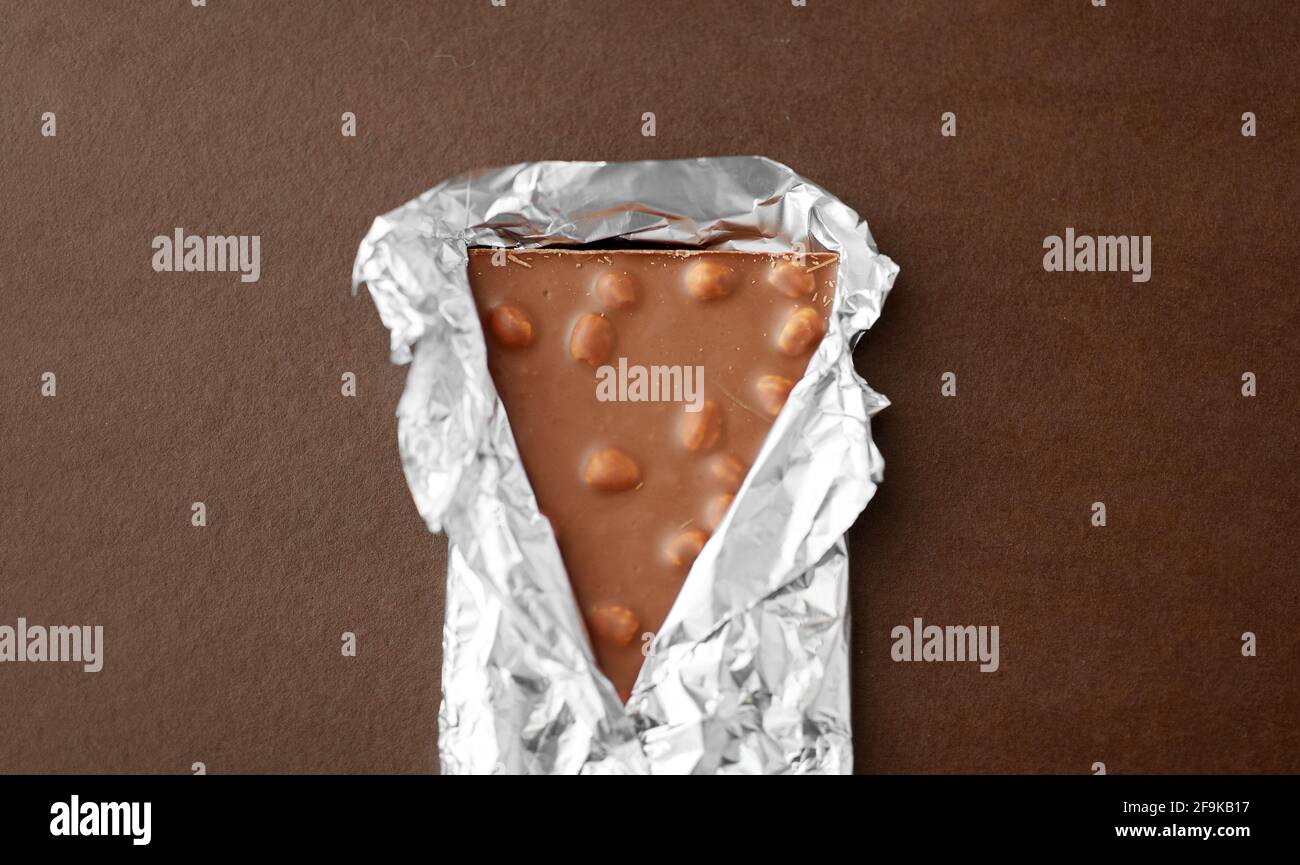 milk chocolate bar with nuts in foil wrapper Stock Photo - Alamy