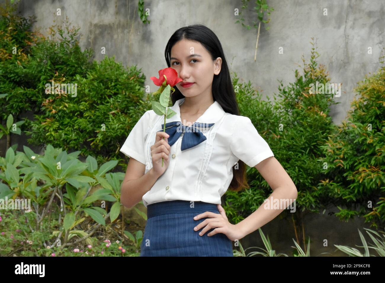 Unemotional Youthful Filipina Person With Flower Stock Photo - Alamy