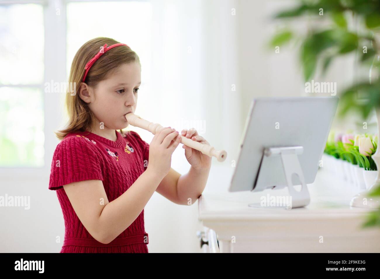 Child playing flute. Remote learning from home. Arts for kid. Little ...