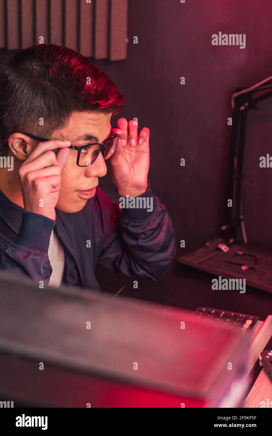 Young man doing different tasks on his computer. Making multimedia ...