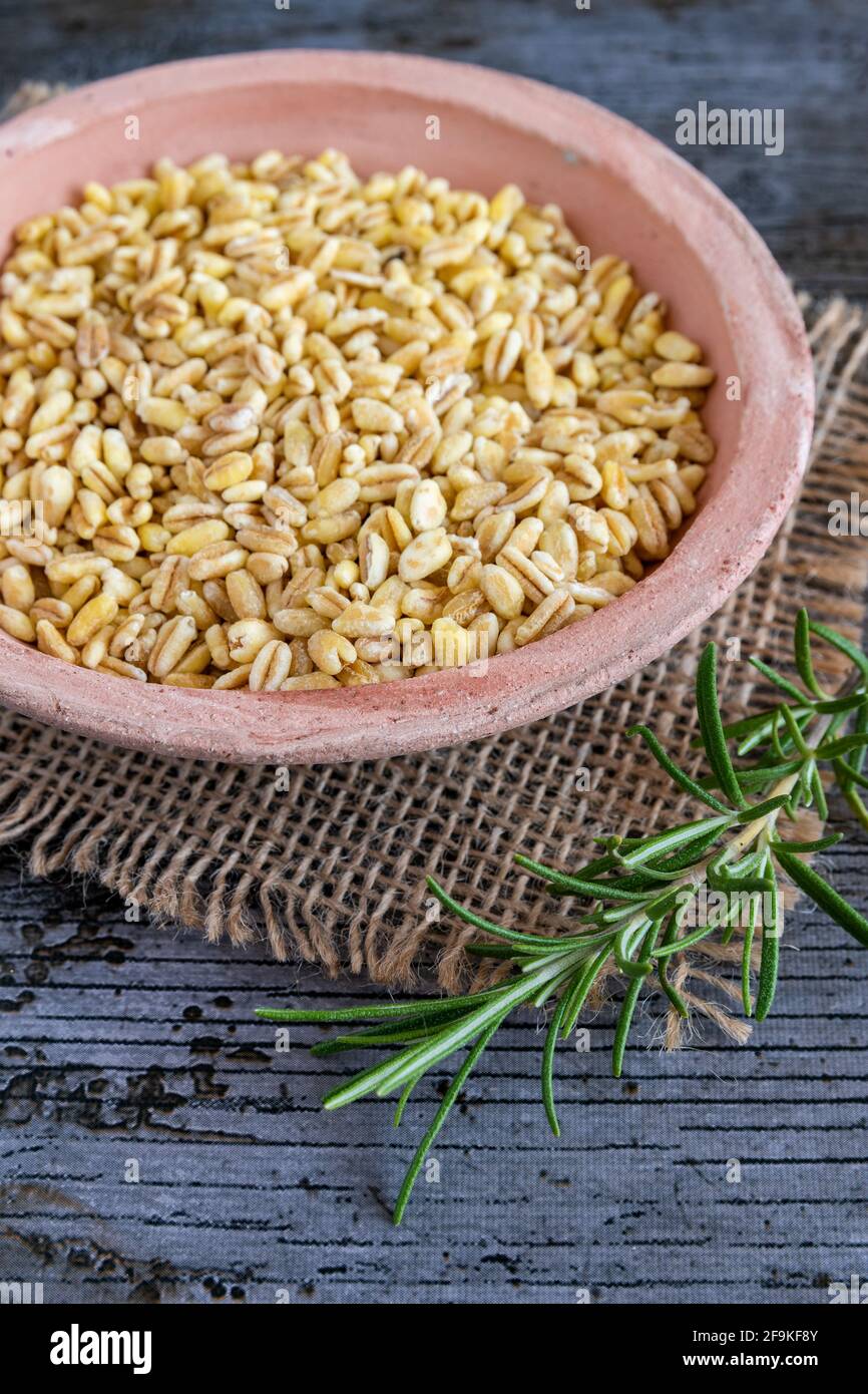 Uncooked wheat grains grown in france on rustic background Stock Photo ...