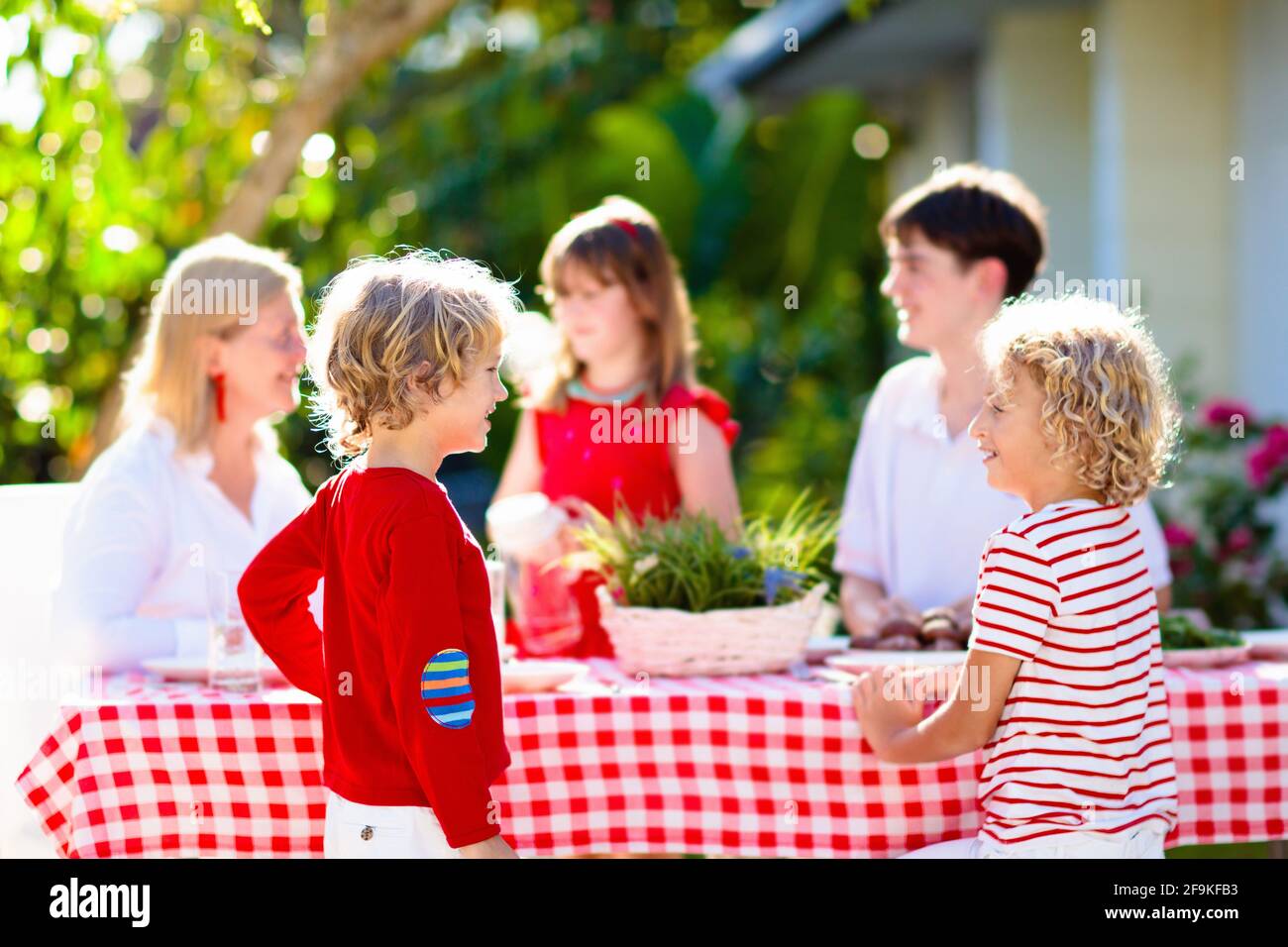 Family eating outdoors. Garden summer fun. Barbecue in sunny backyard ...