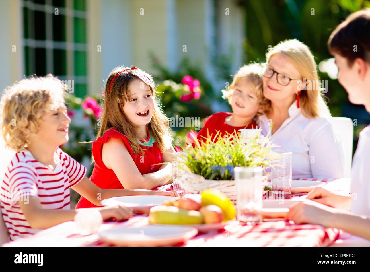 Family eating outdoors. Garden summer fun. Barbecue in sunny backyard ...