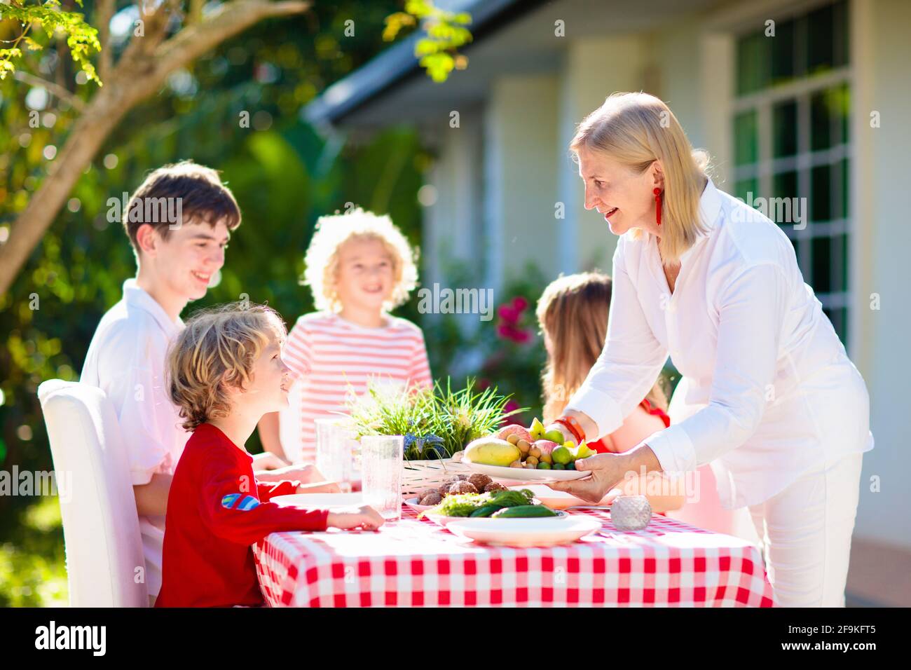 Family eating outdoors. Garden summer fun. Barbecue in sunny backyard ...
