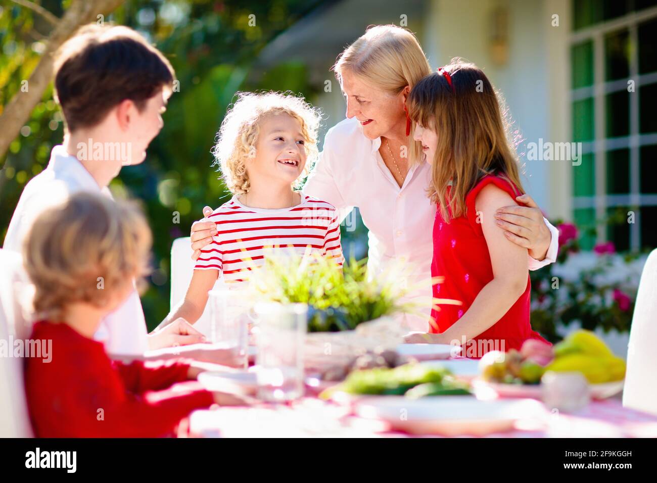 Family eating outdoors. Garden summer fun. Barbecue in sunny backyard ...