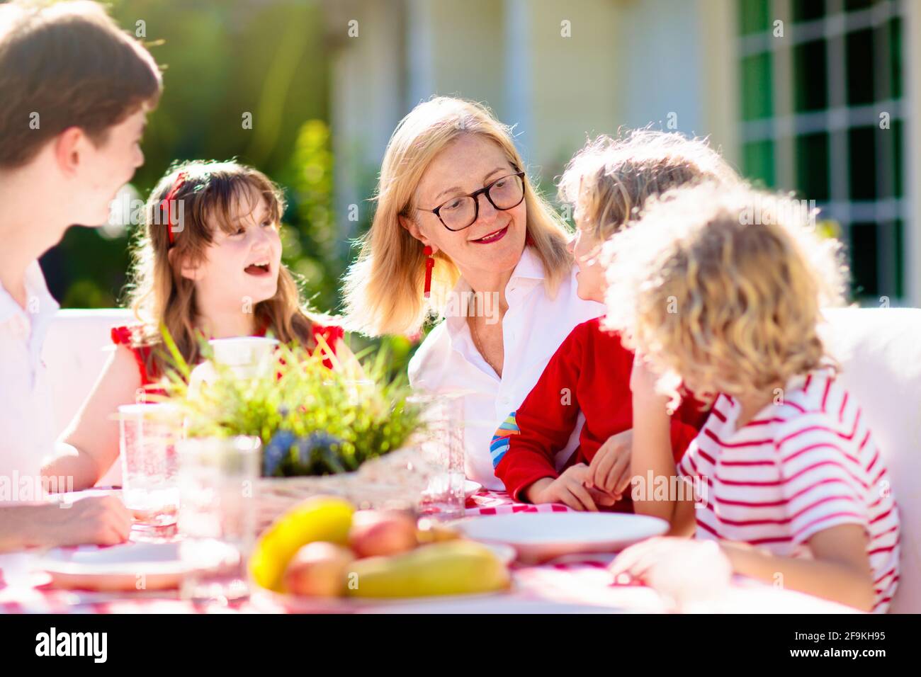 Family eating outdoors. Garden summer fun. Barbecue in sunny backyard ...