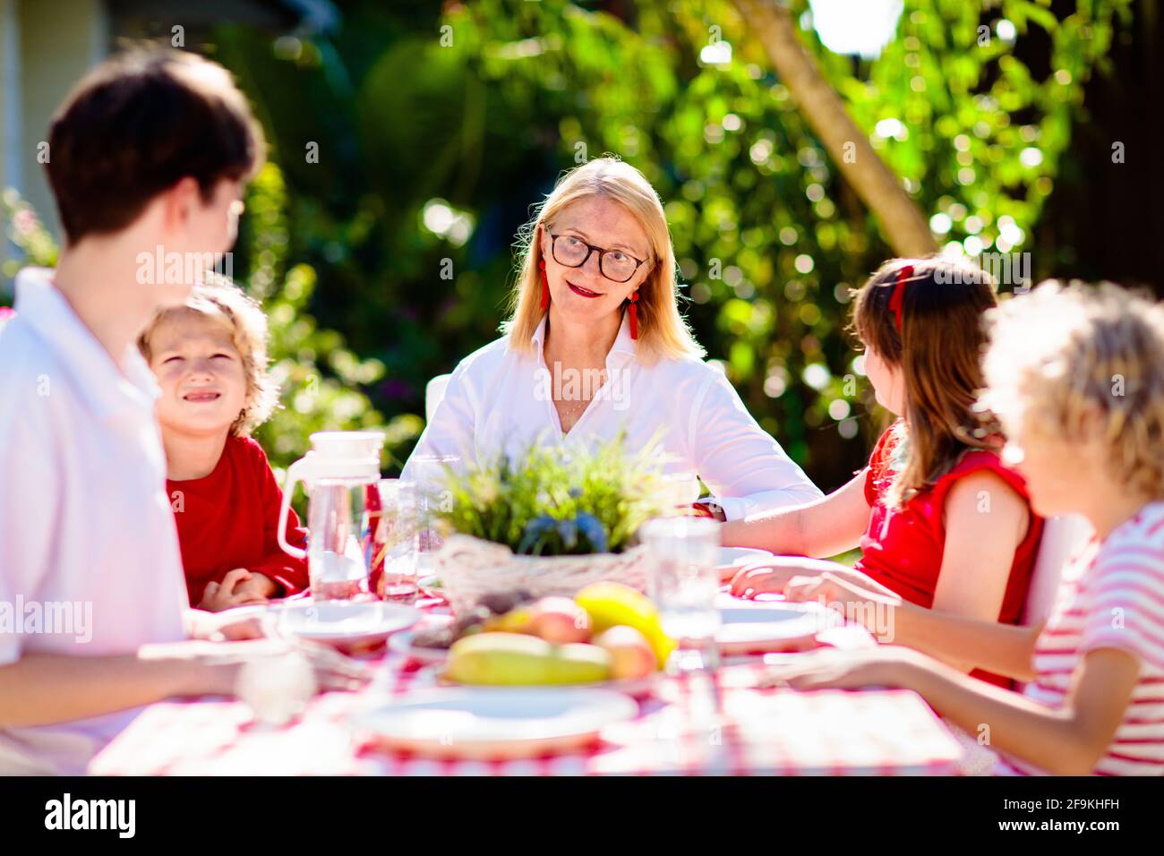 Family eating outdoors. Garden summer fun. Barbecue in sunny backyard ...