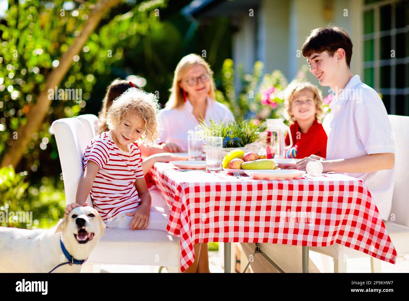 Family eating outdoors. Garden summer fun. Barbecue in sunny backyard ...