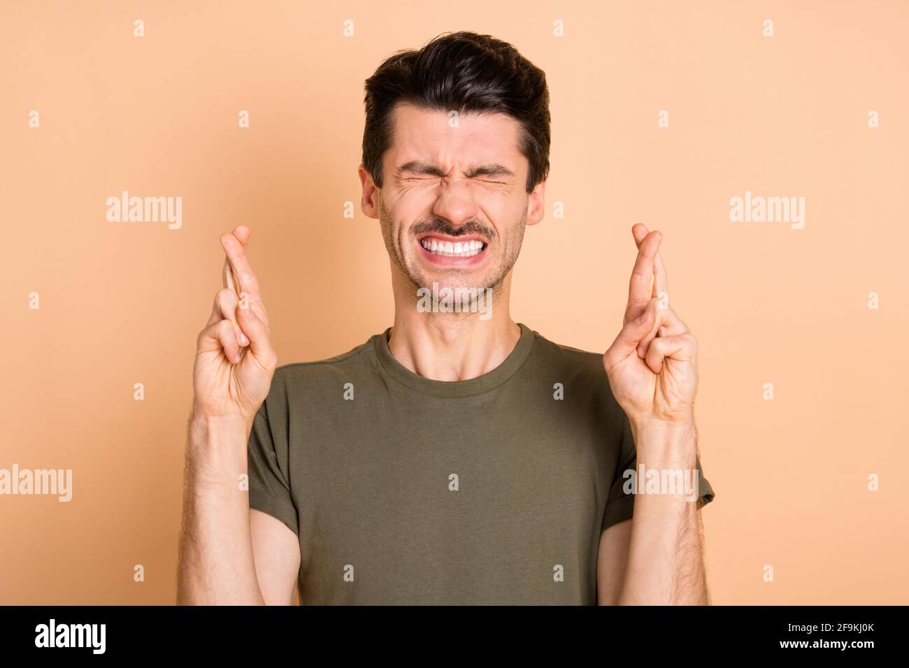Photo portrait of guy crossed fingers make a with hope want to win ...