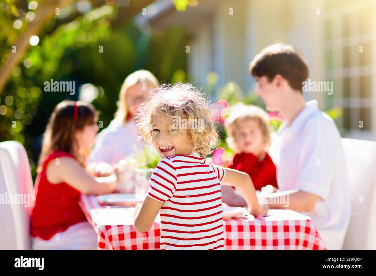 Family eating outdoors. Garden summer fun. Barbecue in sunny backyard ...