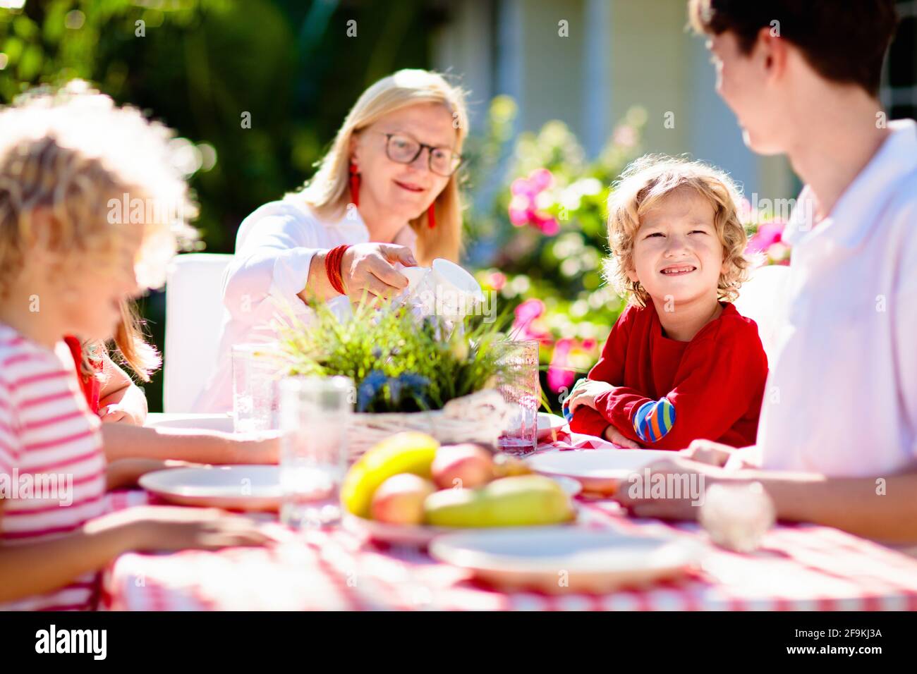 Family eating outdoors. Garden summer fun. Barbecue in sunny backyard ...