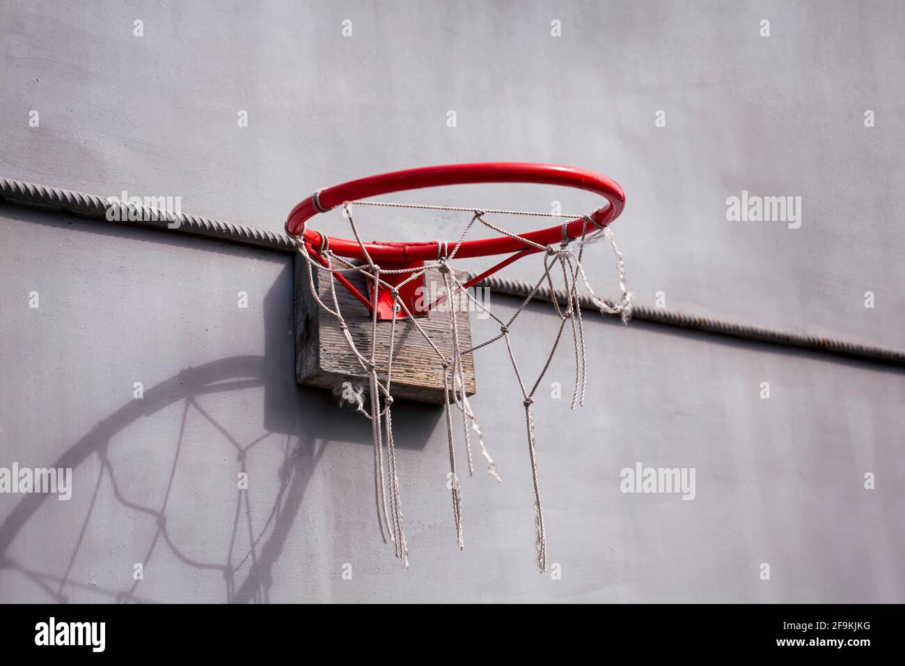 Red basketball hoop attached to gray metal wall Stock Photo - Alamy