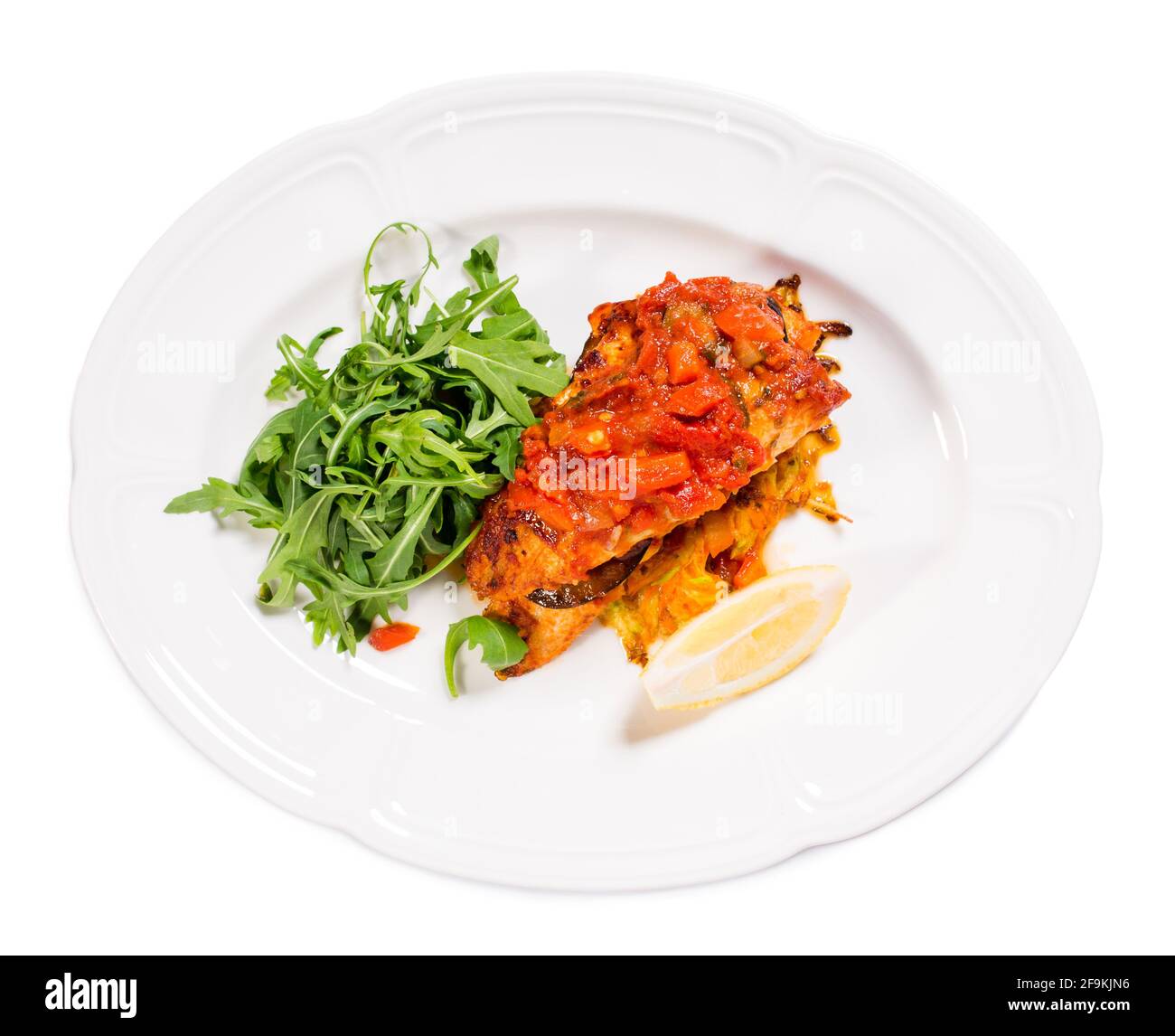 Grilled dorado covered with baked vegetables and heap of arugula as a ...