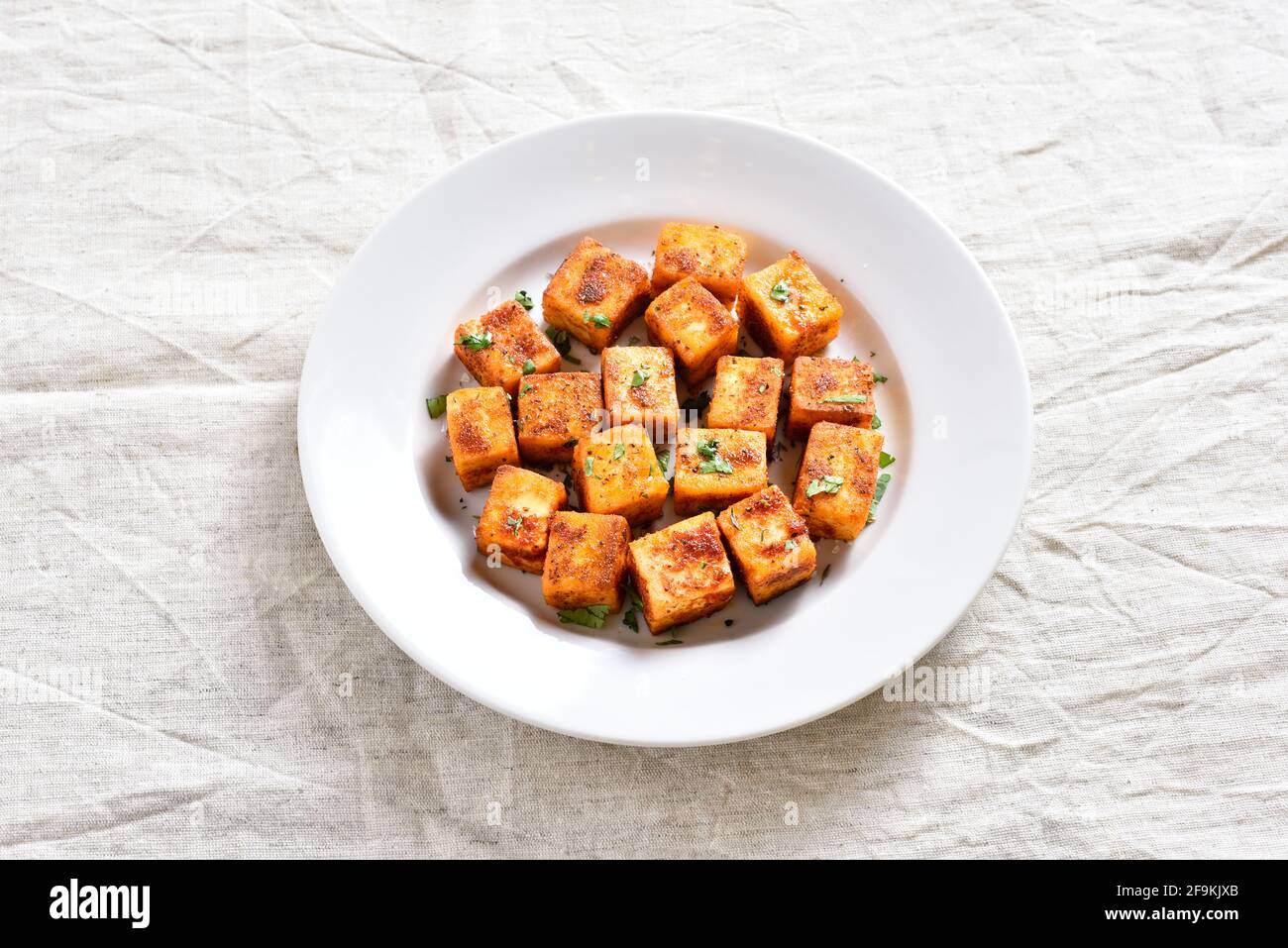 Pan fried paneer. Indian roasted cottage cheese bites on plate over ...