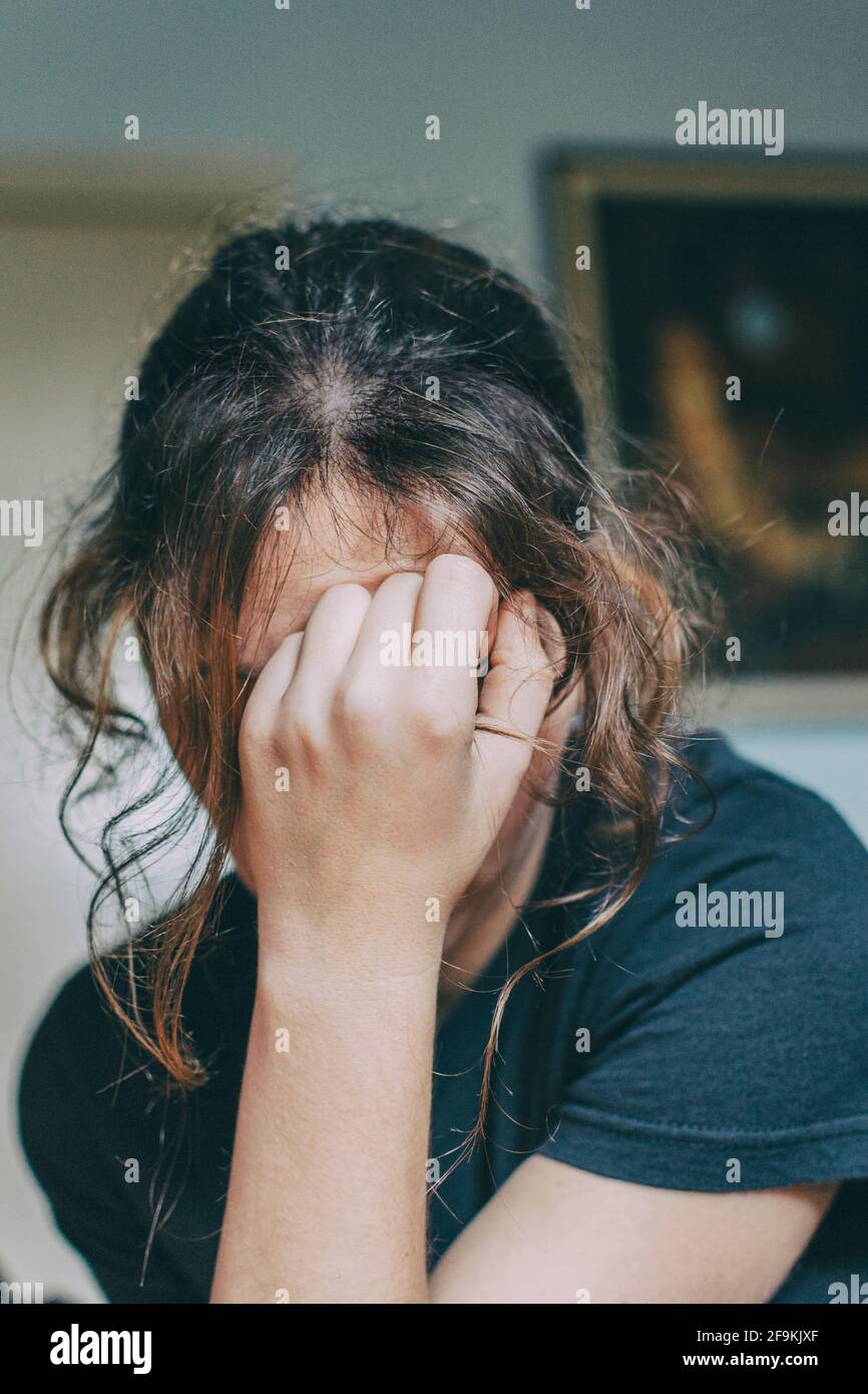 Girl with hand on sad and disappointed face inside her room Stock Photo ...