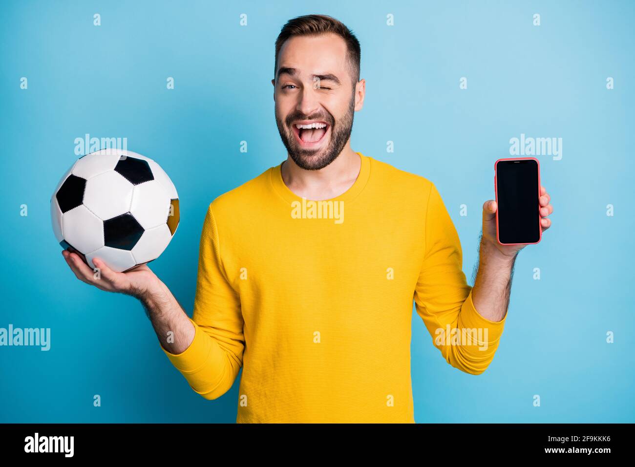 Photo portrait of man with ball smiling showing touchscreen of ...