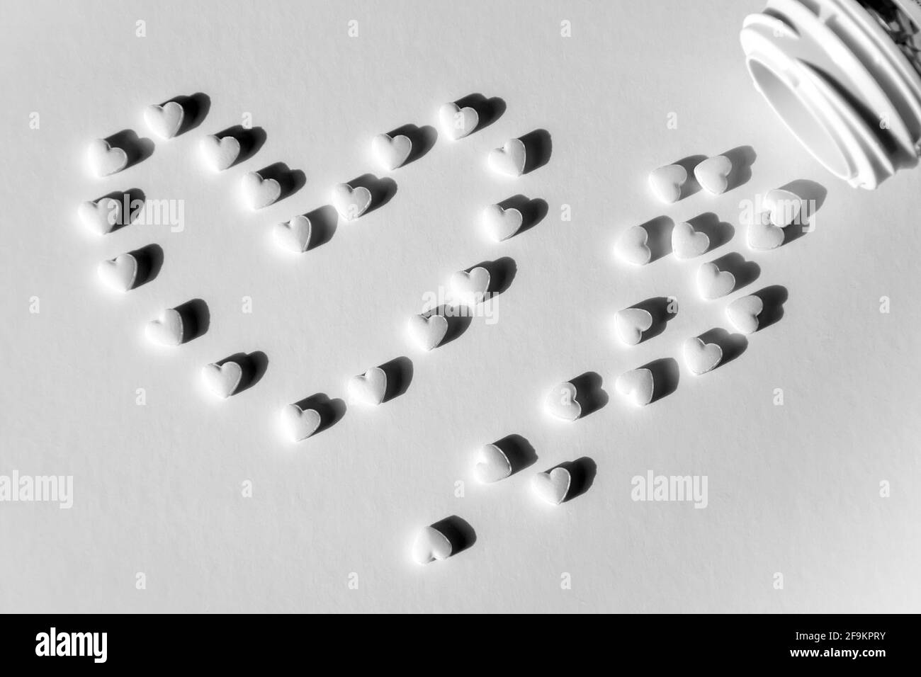 White pills in shape of heart. Hard shadows. Concept of health ...