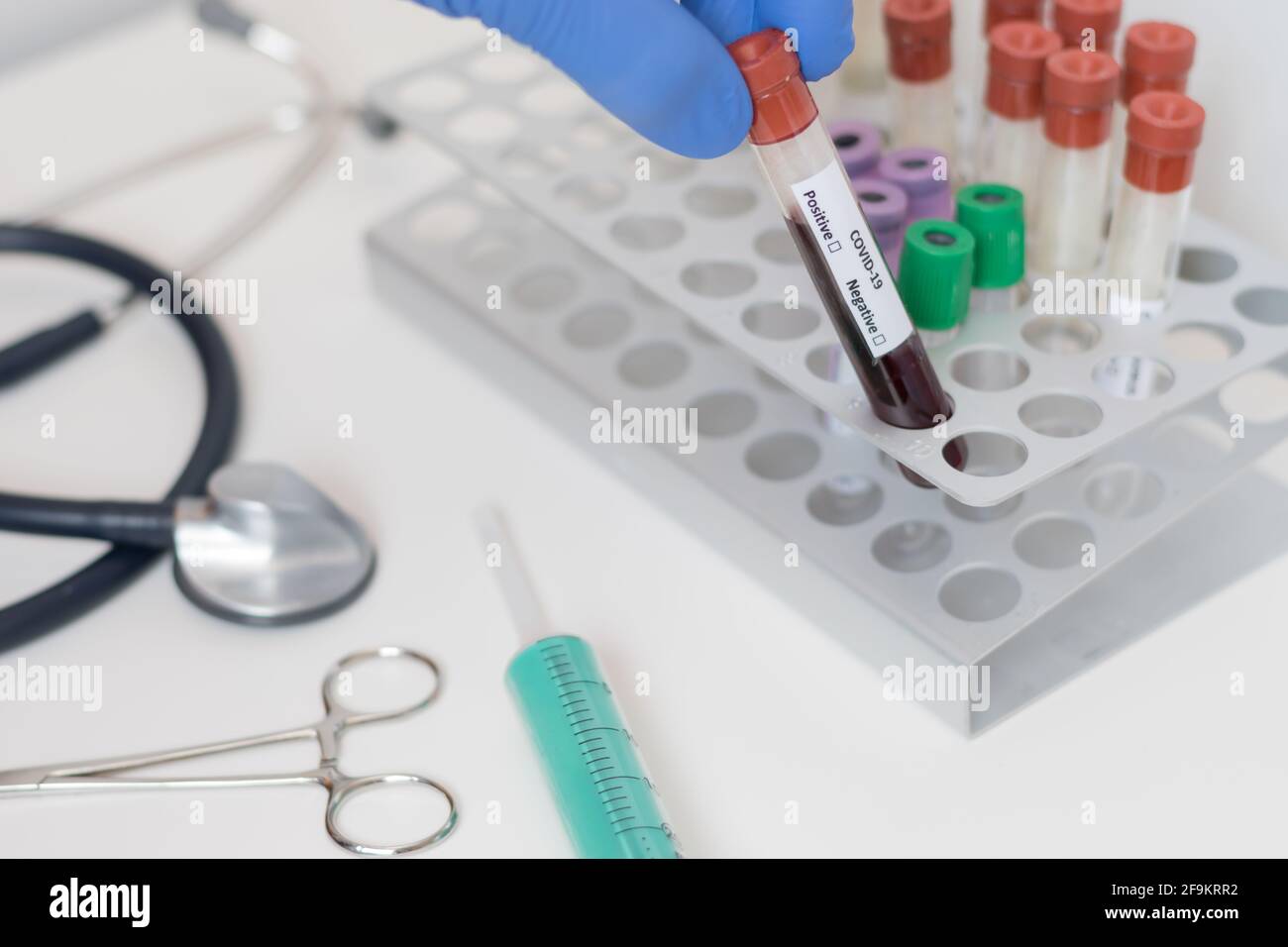 in a lab you see a hand holding a test tube with a positive blood test ...