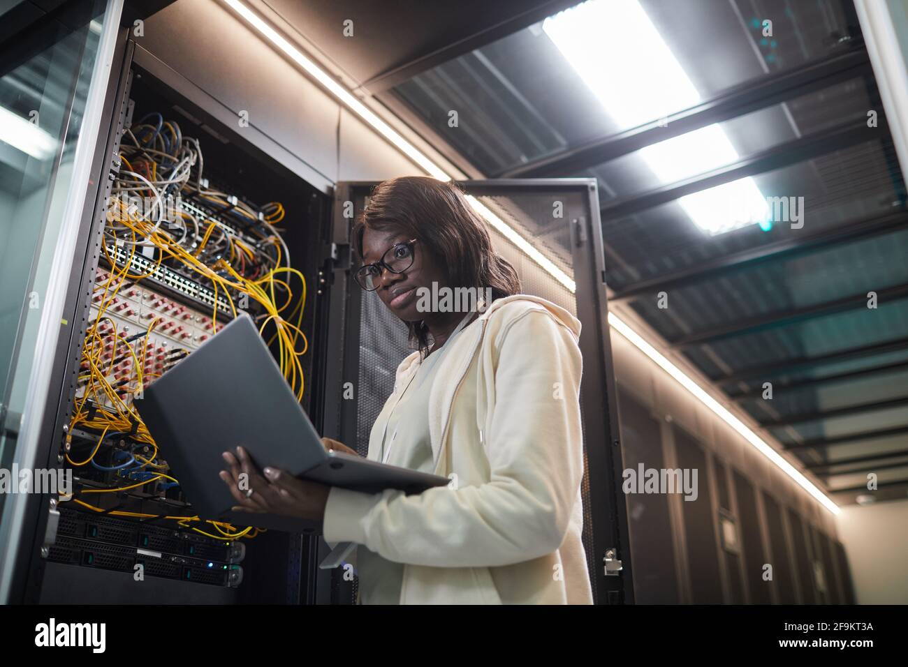 Low angle portrait of African-American female network engineer standing ...