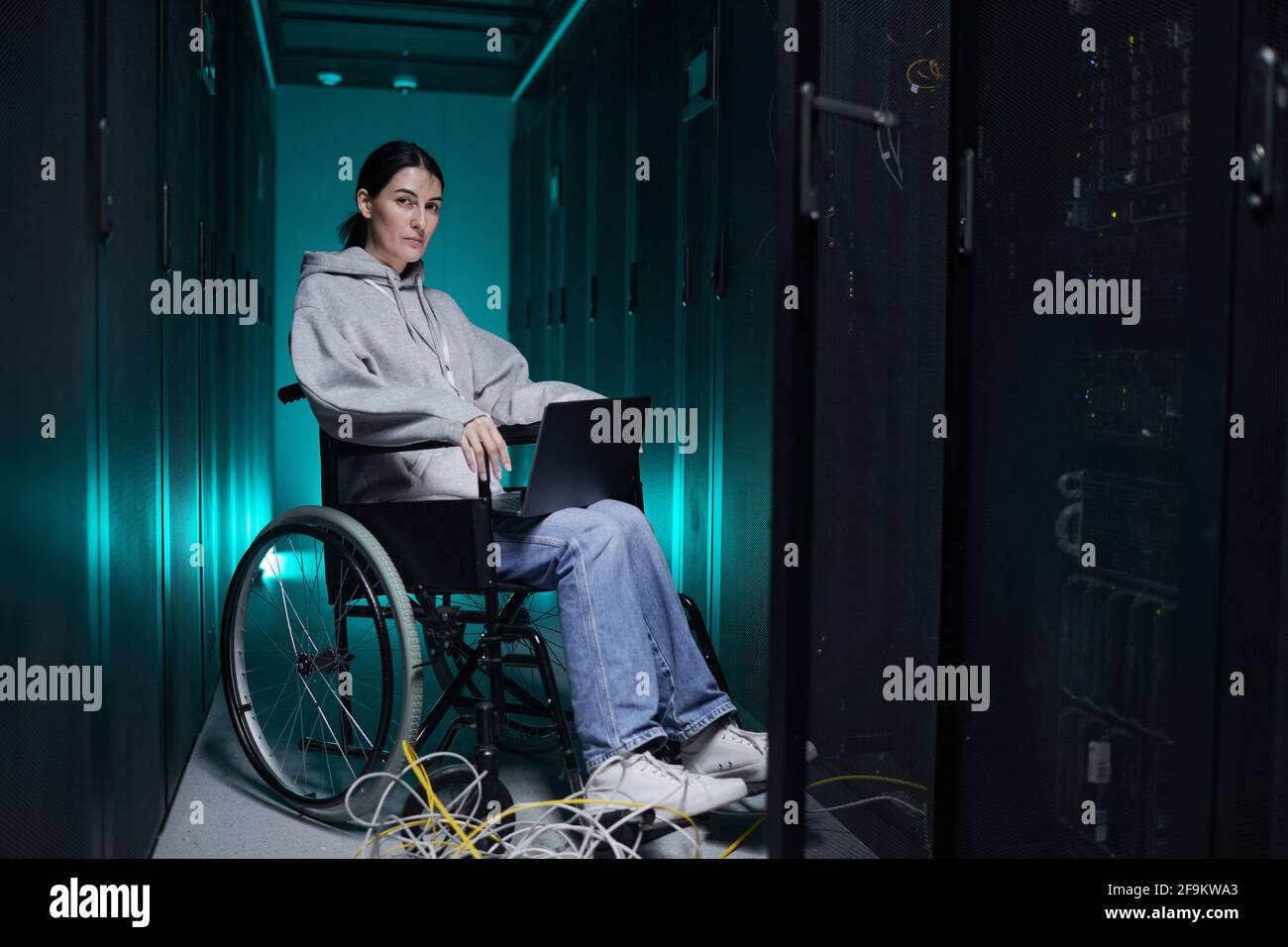 Full length portrait of disabled woman looking at camera while using ...