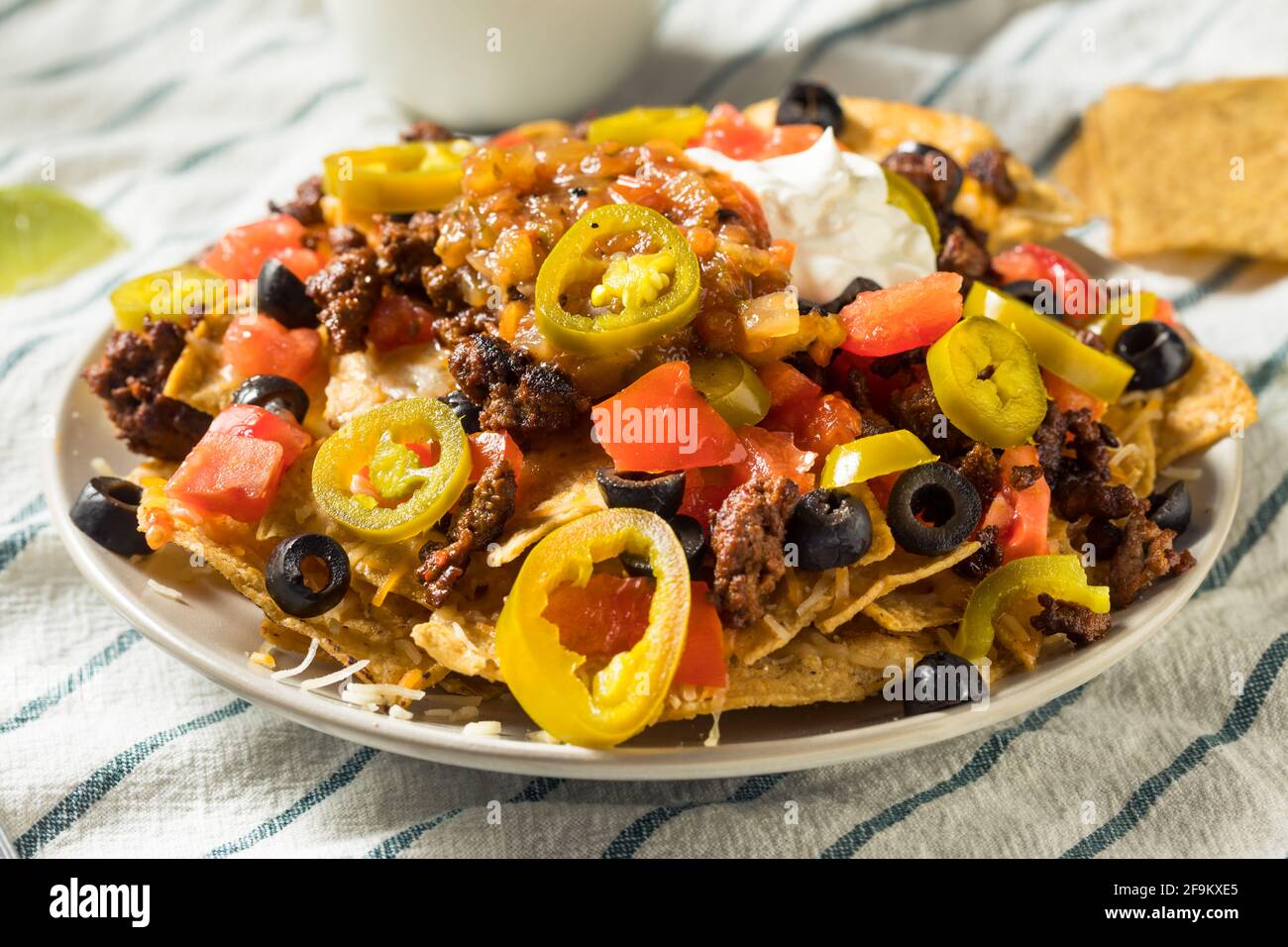 Homemade Cheesy Beef Nachos with Olives and Jalapenos Stock Photo - Alamy