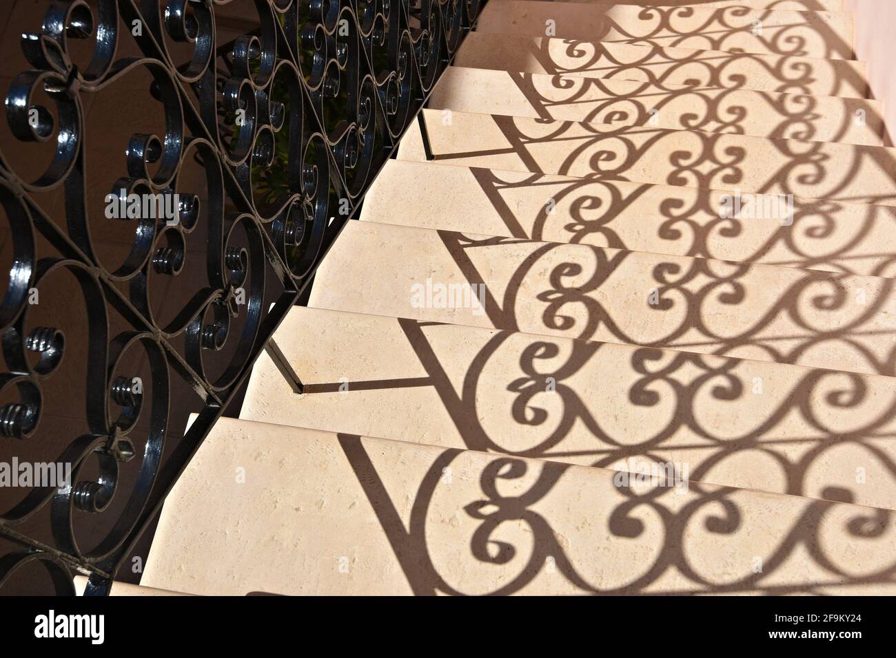 Handcrafted iron railing silhouette on a pink marble staircase in ...