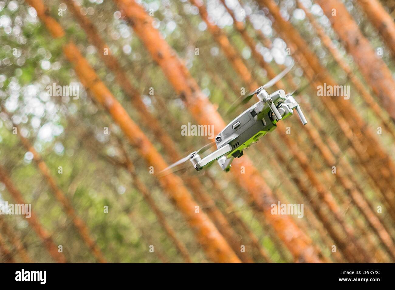 Unmanned drone flies against the background of the nature of the forest ...