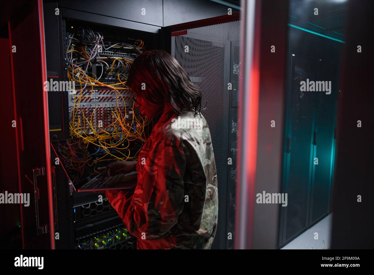 Back view at African-American woman managing computer network while ...