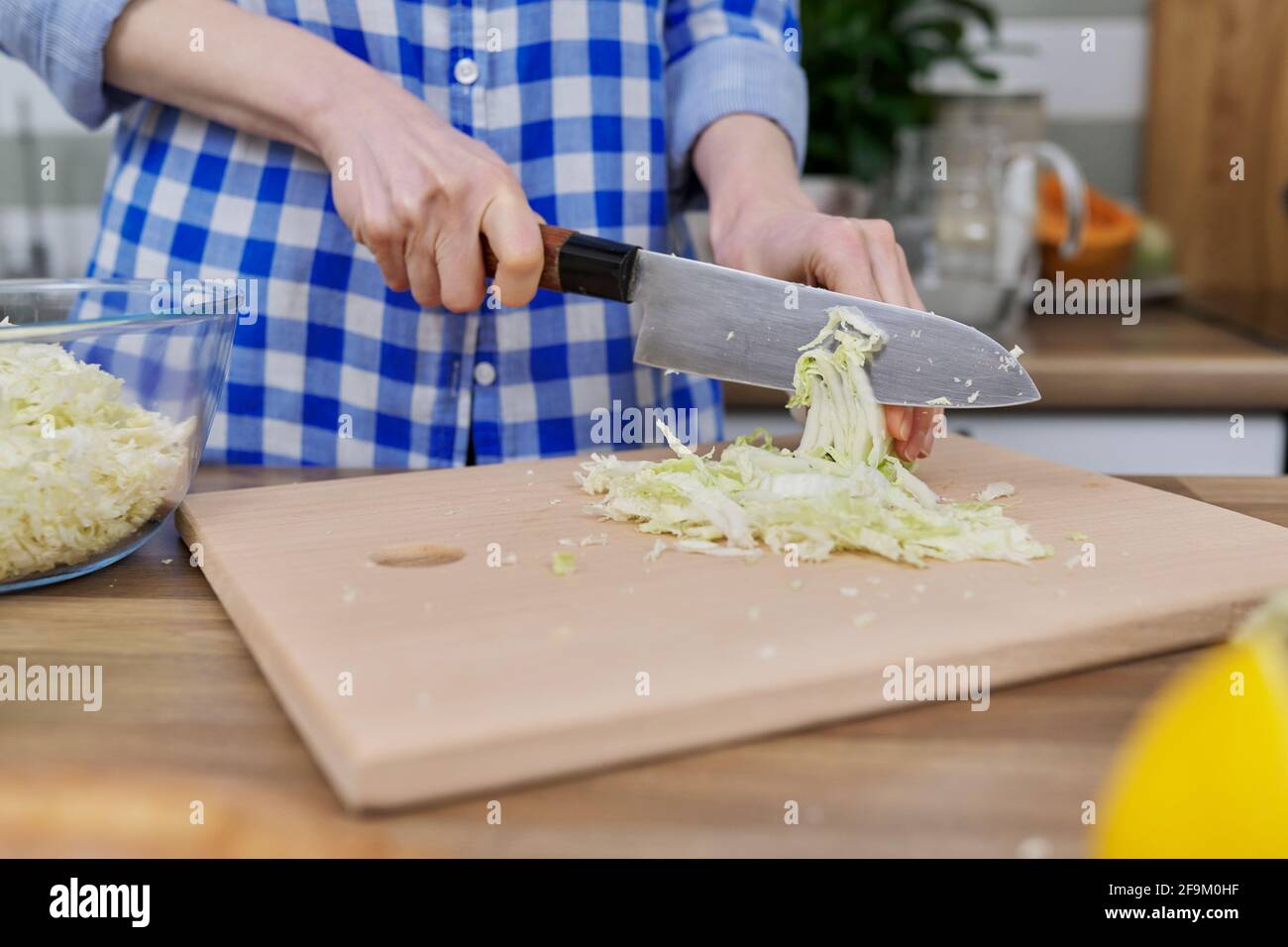 Close-up of woman's hand cutting Chinese cabbage on kitchen board Stock ...