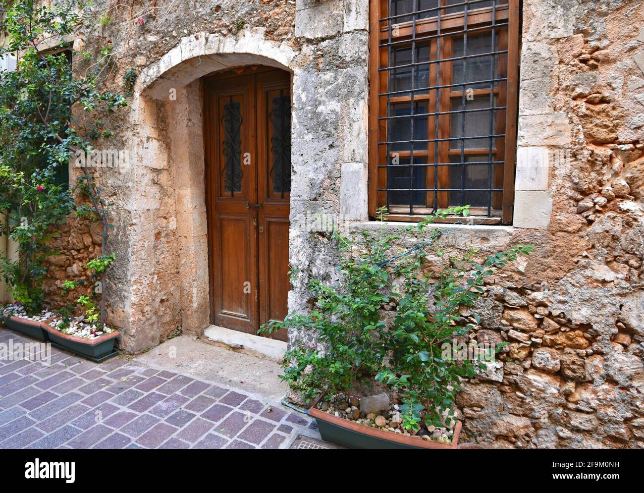 Venetian style house facade with a stone wall and an arched antique ...