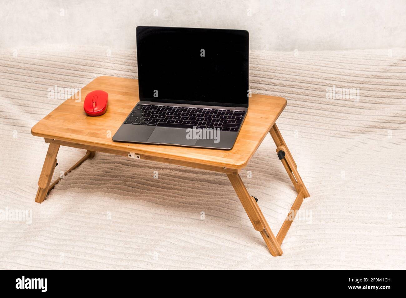 laptop and a computer mouse on a laptop stand on a bed. Concept Stock ...
