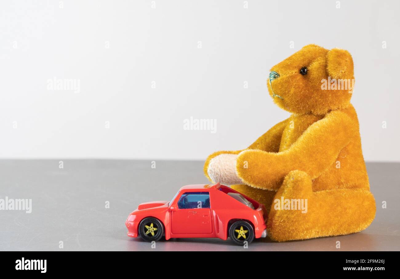 Teddy bear with a red toy car Stock Photo - Alamy