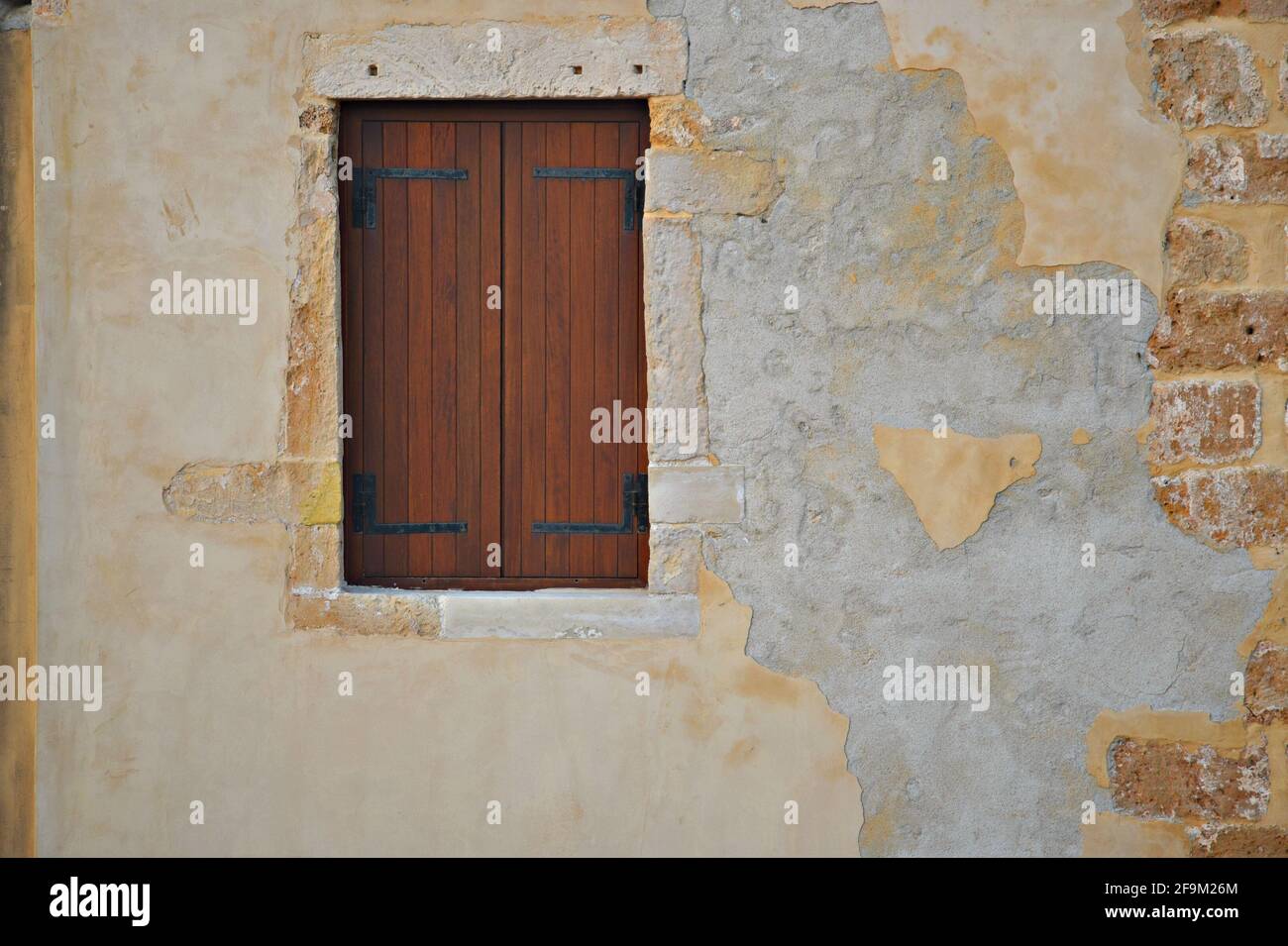 Antique wooden window shutters on a faded Venetian stucco wall at the ...