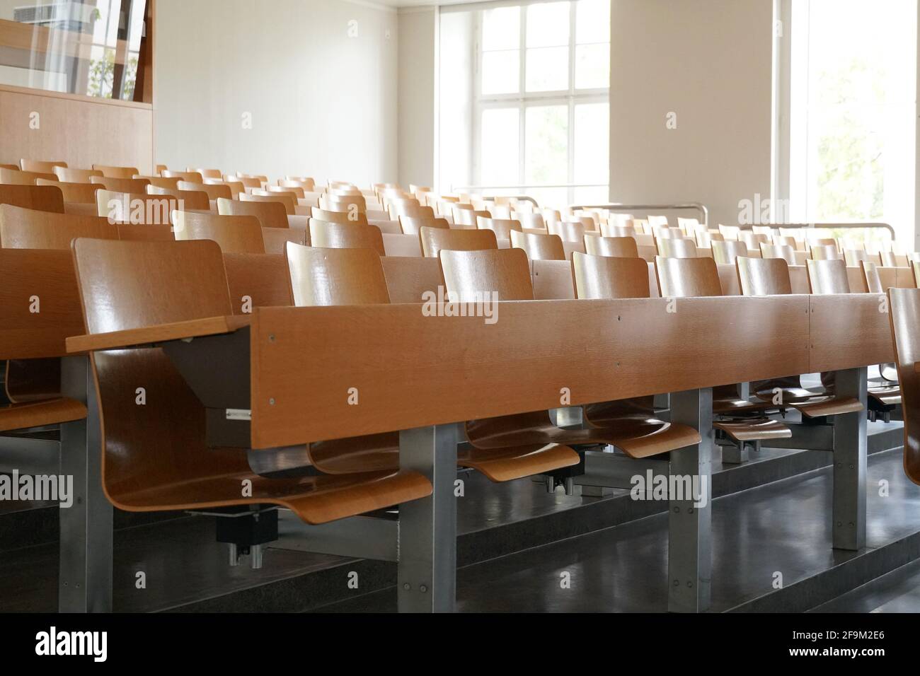 View on empty auditorium at university with wooden chairs and banks and ...