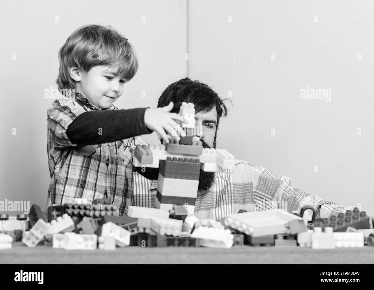Dad and kid build plastic blocks. Child care development and upbringing ...