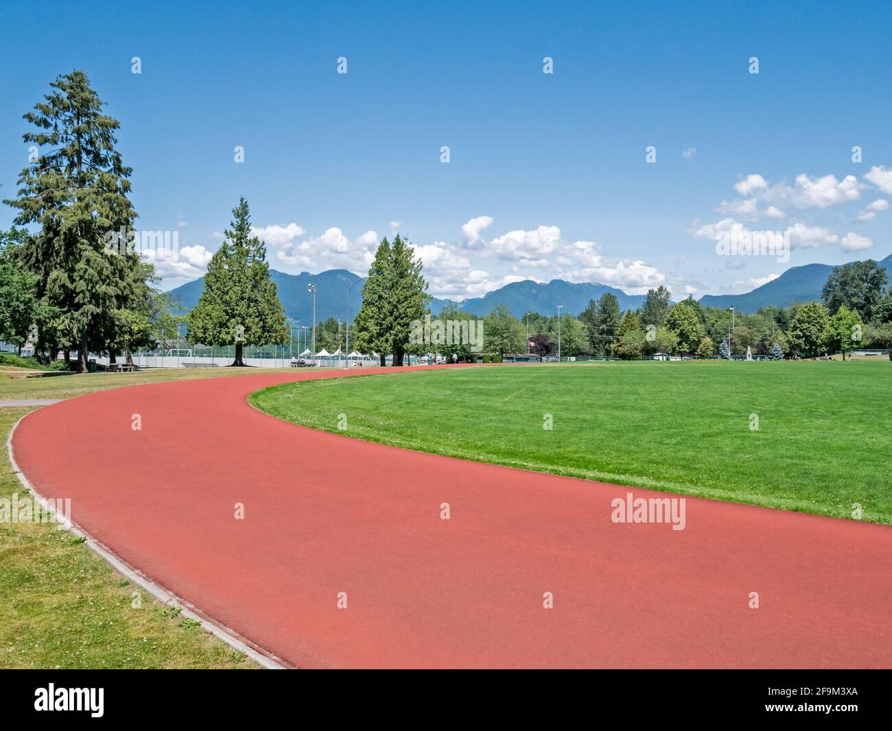 Red jogging track of recreational stadium on bright sunny day Stock ...