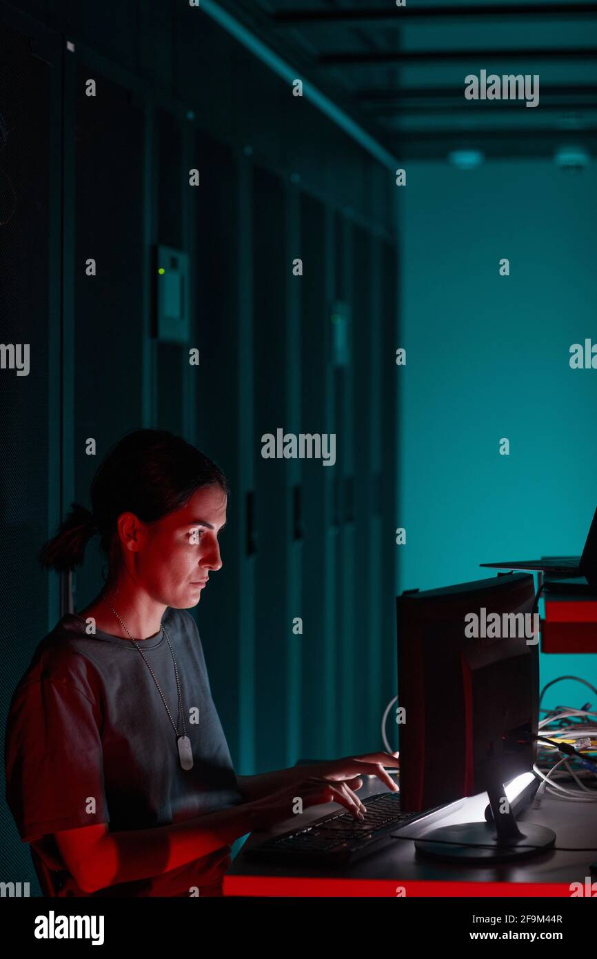 Vertical side view portrait of female IT engineer using computer while ...