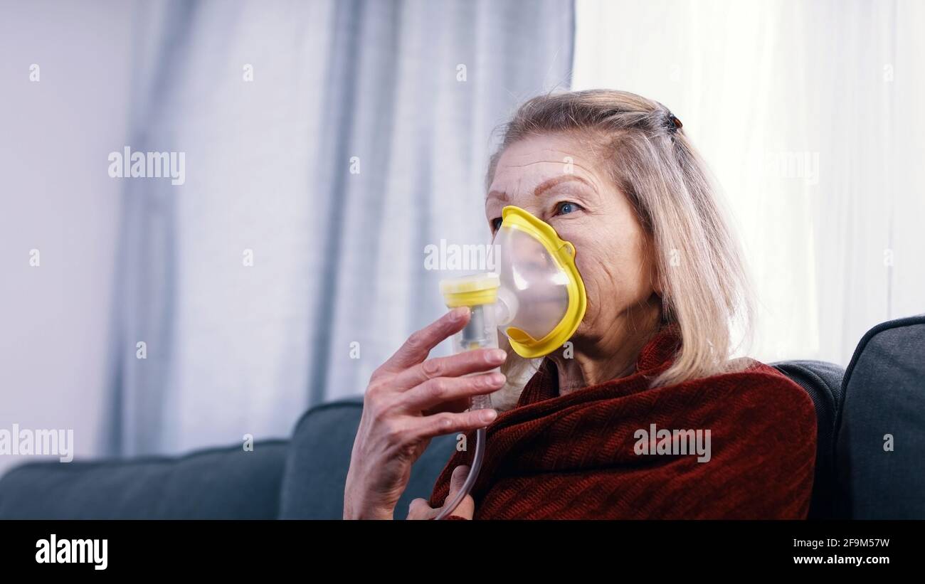 Vulnerable old woman in quarantine using oxygen inhaler and changing ...