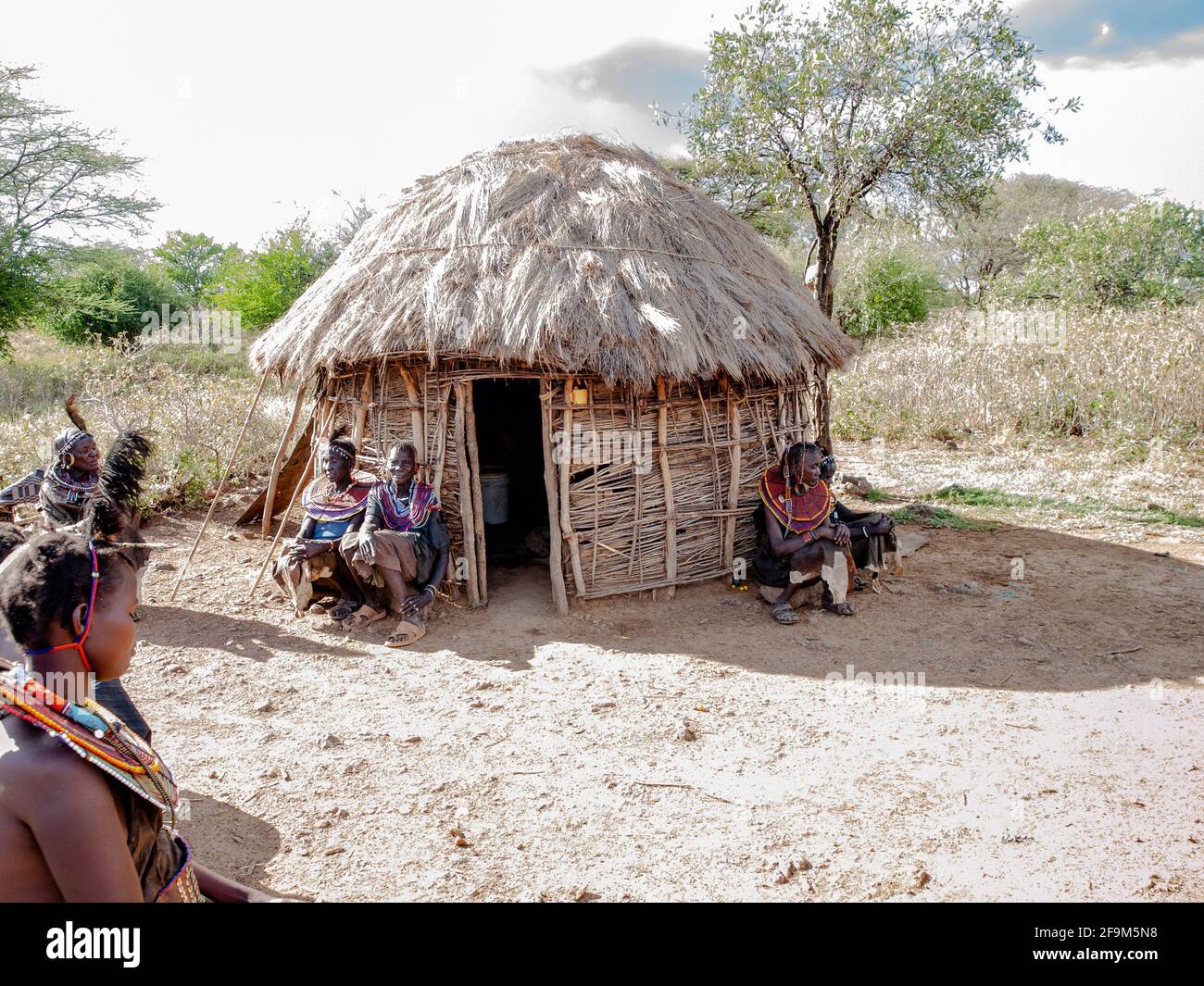 Native women in traditional garb, posing in village. The Pokot people ...
